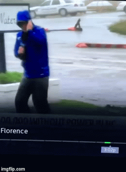 Reporter dramatically braces against wind while 2 guys just stroll by ...